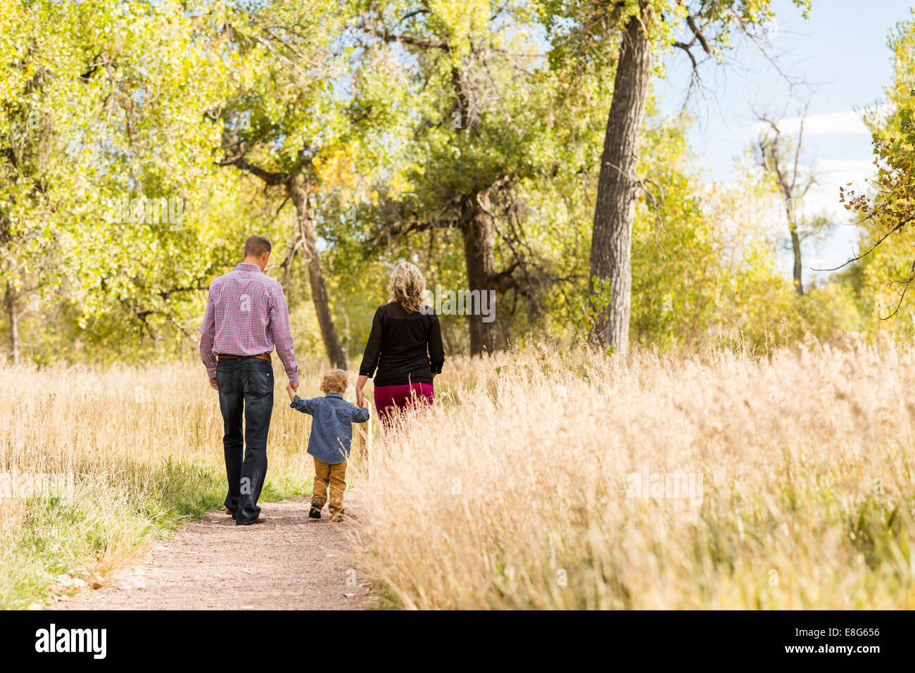 Lovely family enjoying weekend in open space park in early Autumn Stock ...