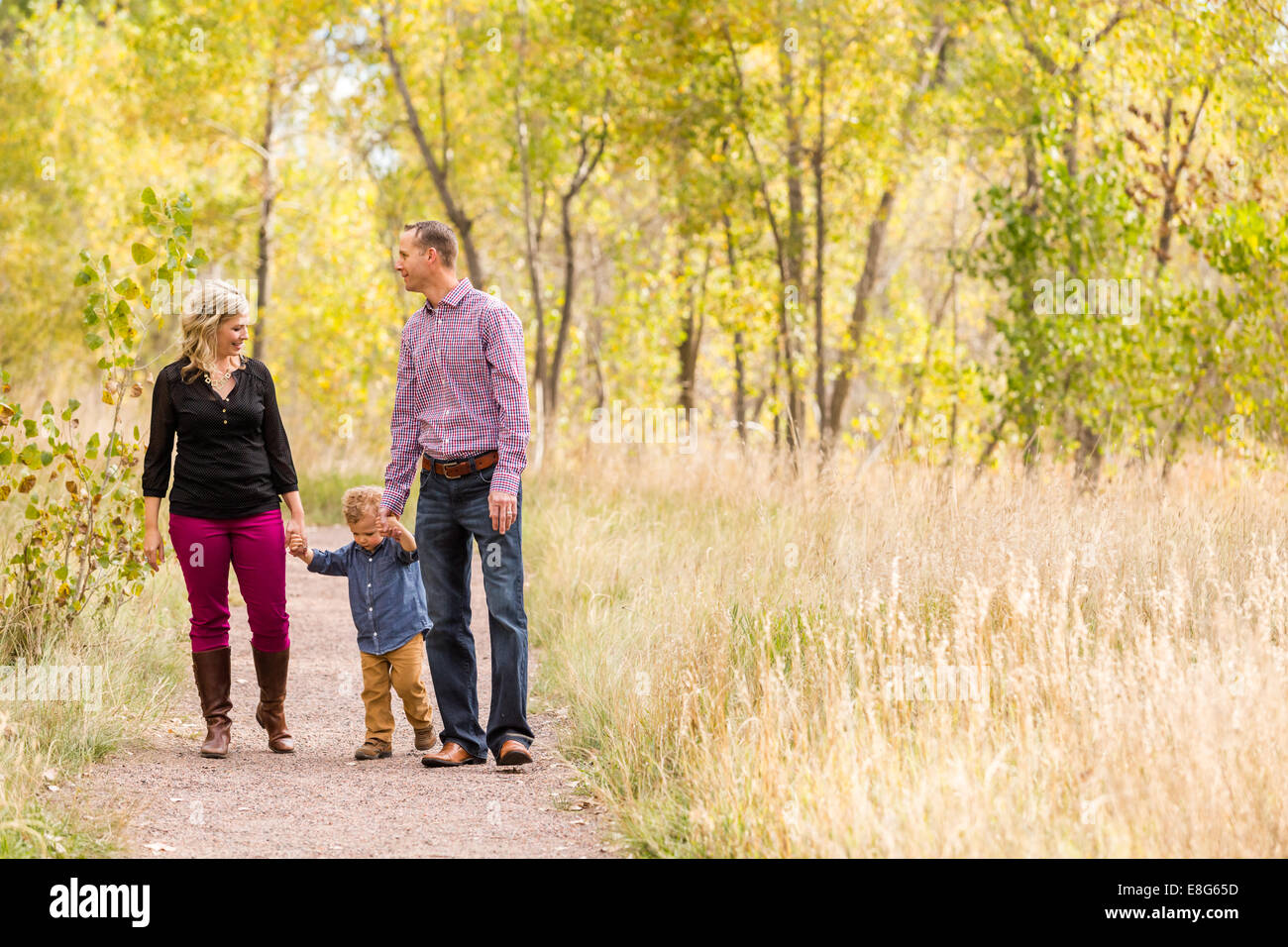 Lovely family enjoying weekend in open space park in early Autumn Stock ...
