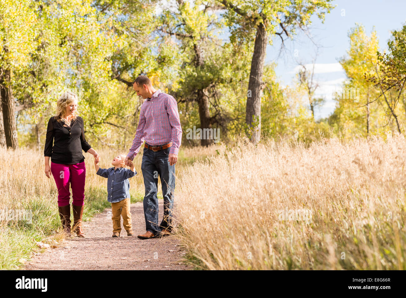 Lovely family enjoying weekend in open space park in early Autumn Stock ...