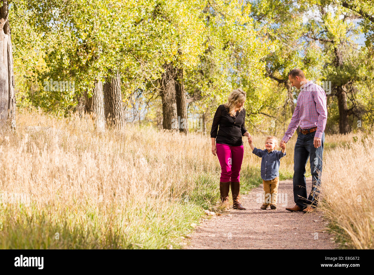 Lovely family enjoying weekend in open space park in early Autumn Stock ...