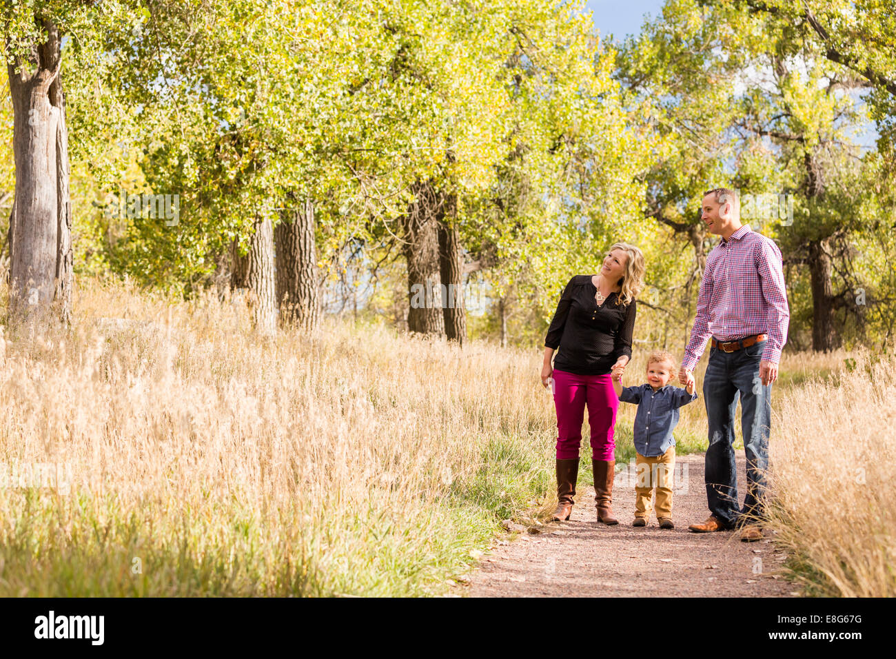 Lovely family enjoying weekend in open space park in early Autumn Stock ...