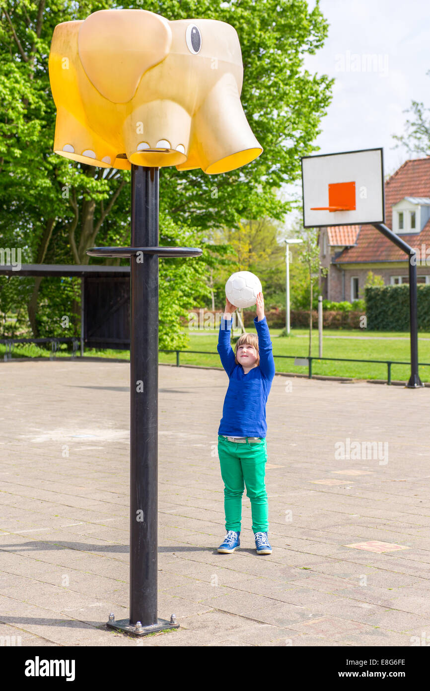 young girl aiming ball at basket like elephant Stock Photo - Alamy