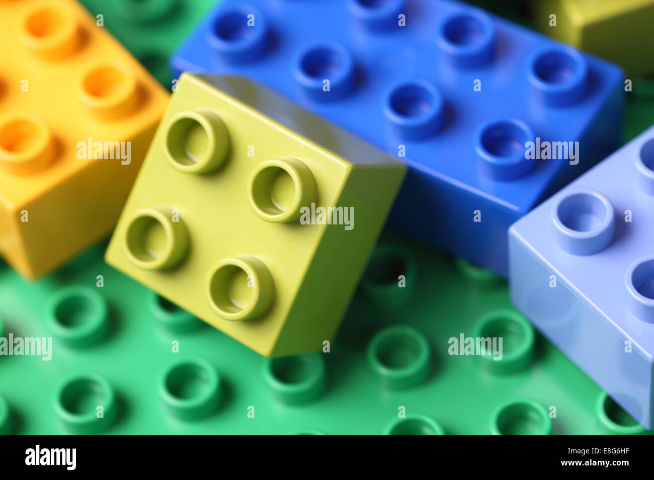 Plastic toy blocks on a green baseplate Stock Photo - Alamy