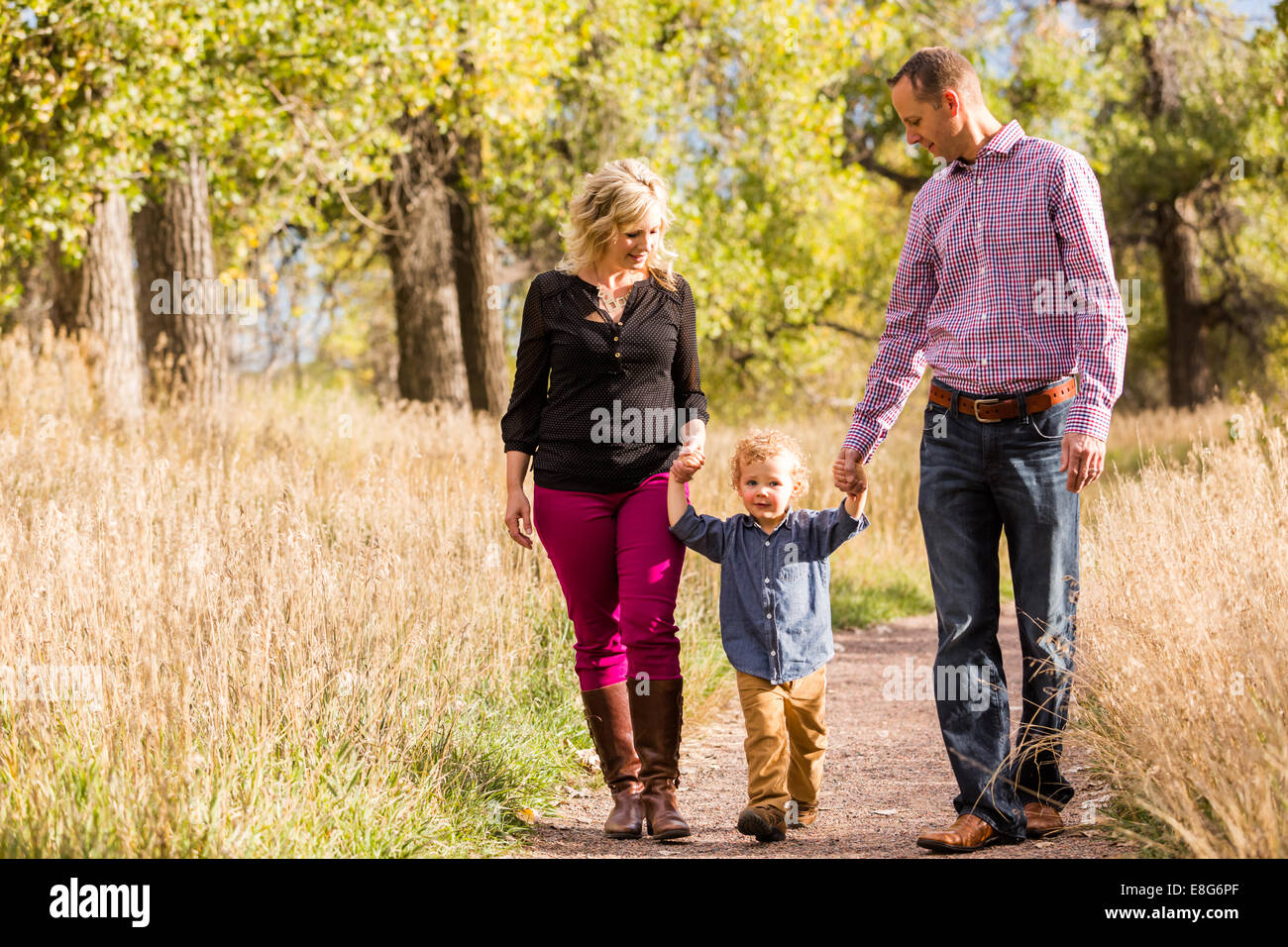 Lovely family enjoying weekend in open space park in early Autumn Stock ...