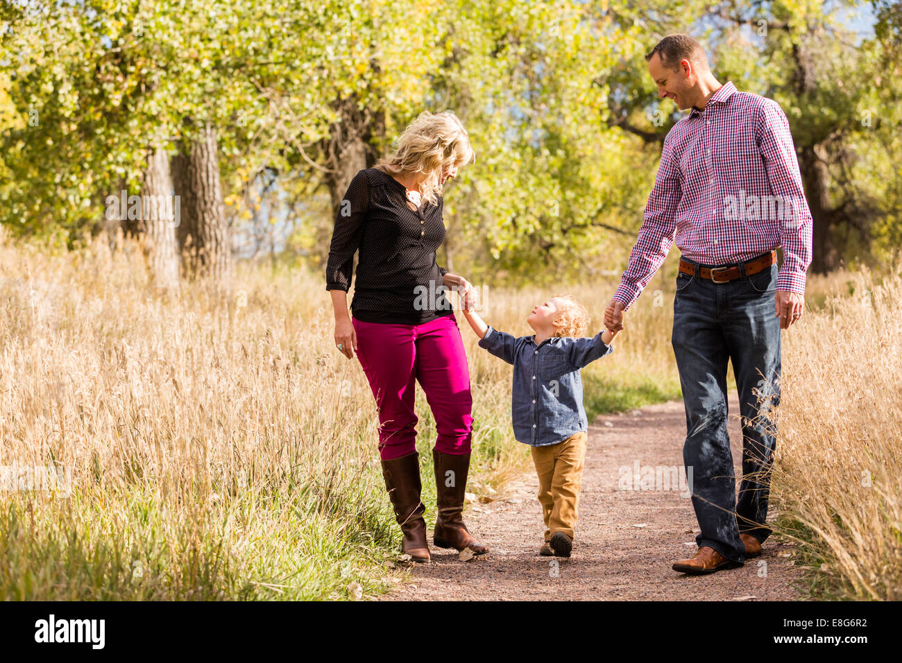 Lovely family enjoying weekend in open space park in early Autumn Stock ...
