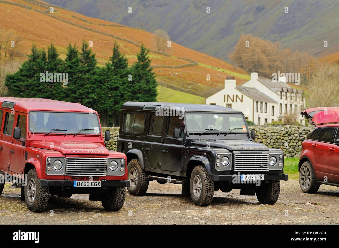 Land Rover Defenders and a Range Rover Evoque parked on a gravel car ...
