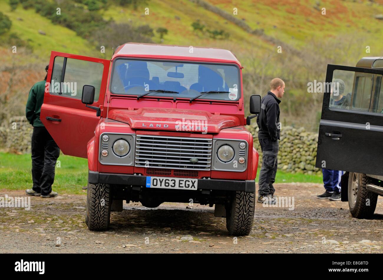 Land Rover Defender parked with door open on a gravel car park in the ...