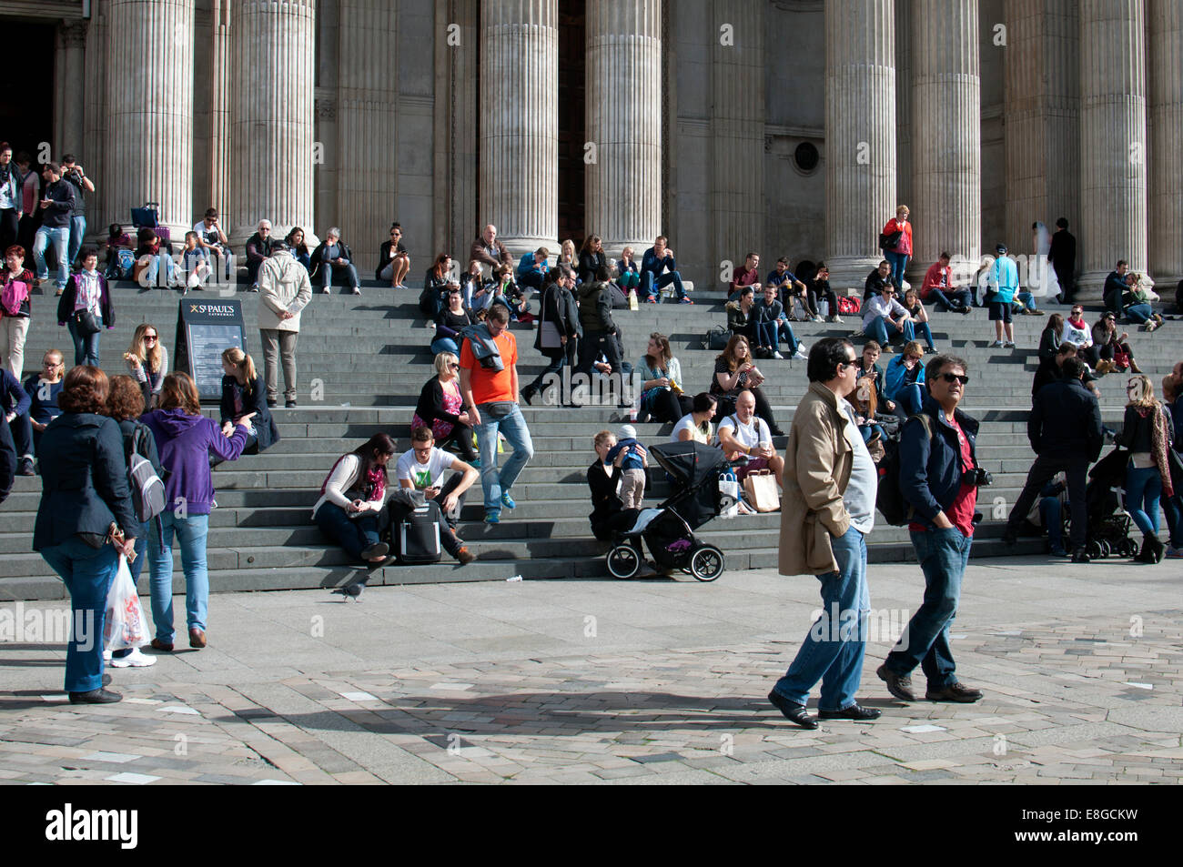 People sitting on the west front steps of St. Paul`s Cathedral, London ...