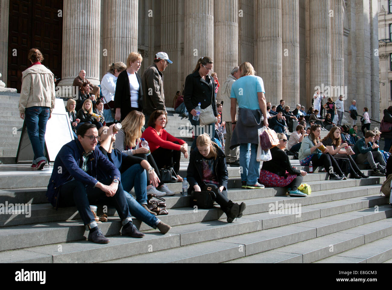 People sitting on the west front steps of St. Paul`s Cathedral, London ...