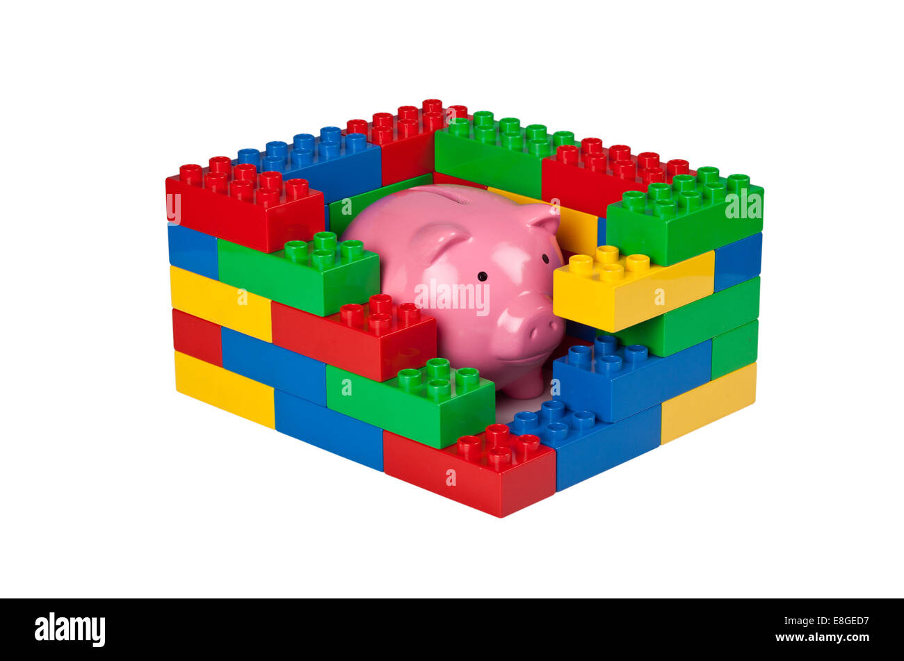 Piggy bank surrounded by a wall made by toy blocks isolated on white ...