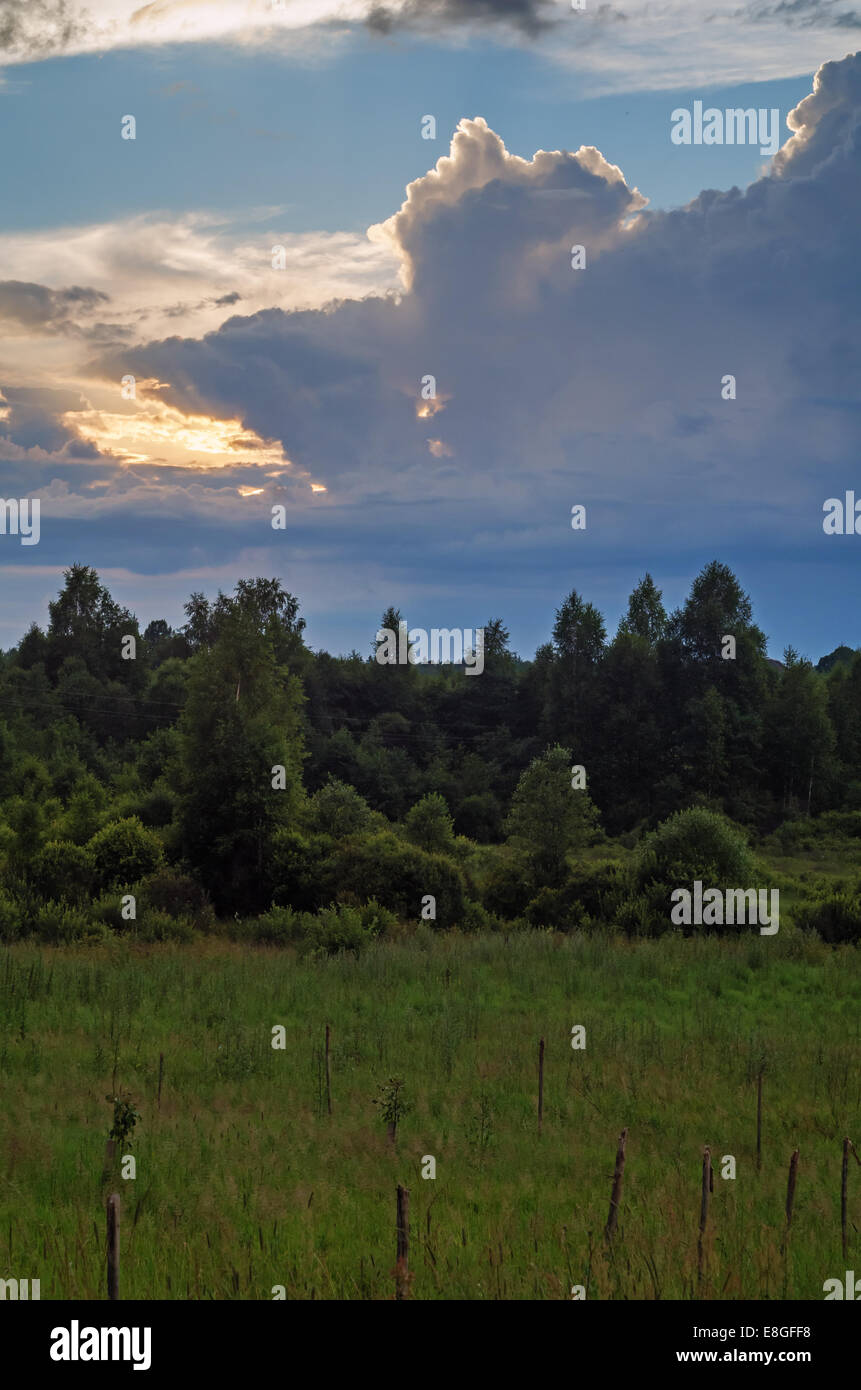 Sunset clouds over meadow Stock Photo - Alamy