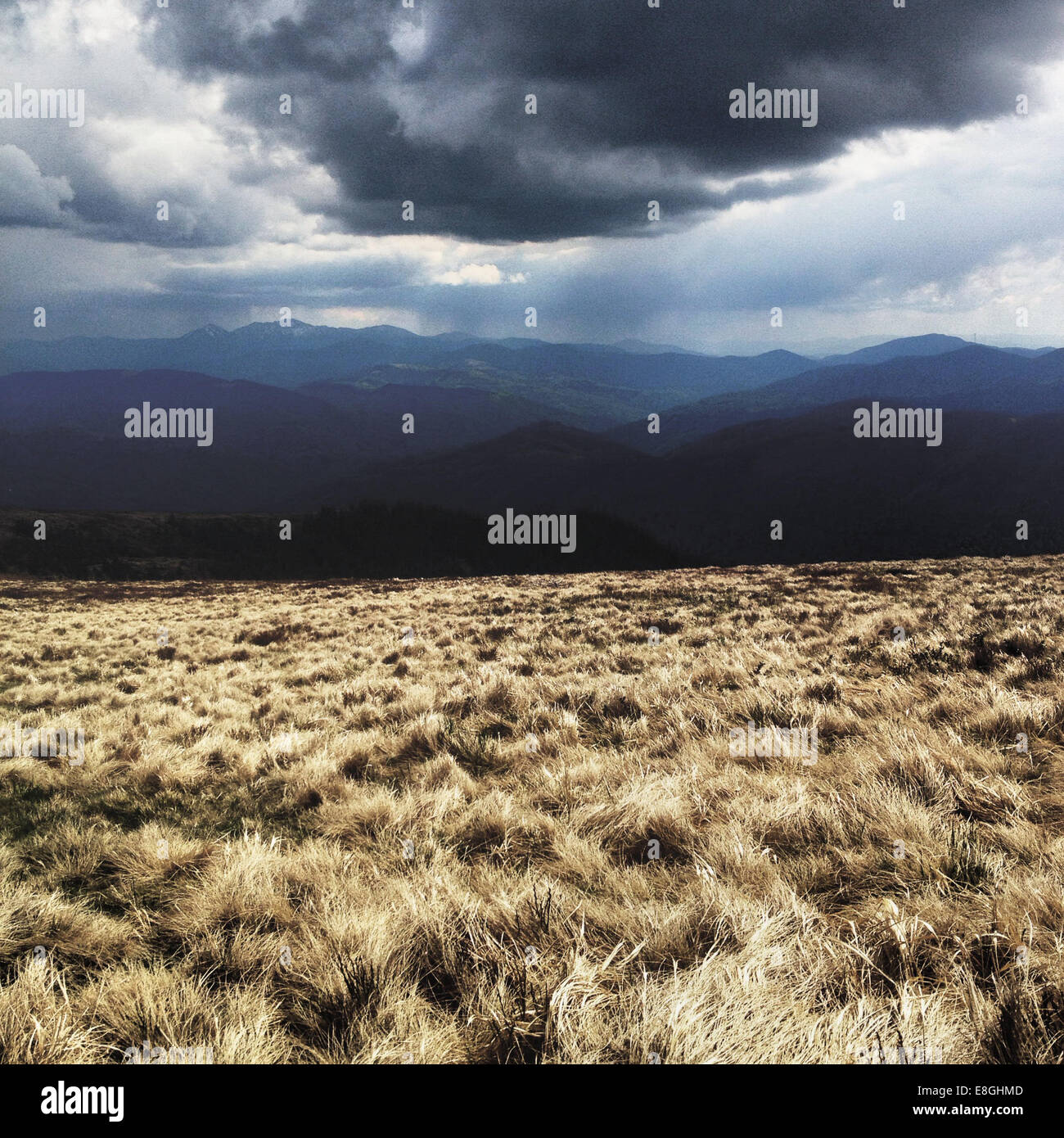 Heavy cloud over field and mountains Stock Photo - Alamy
