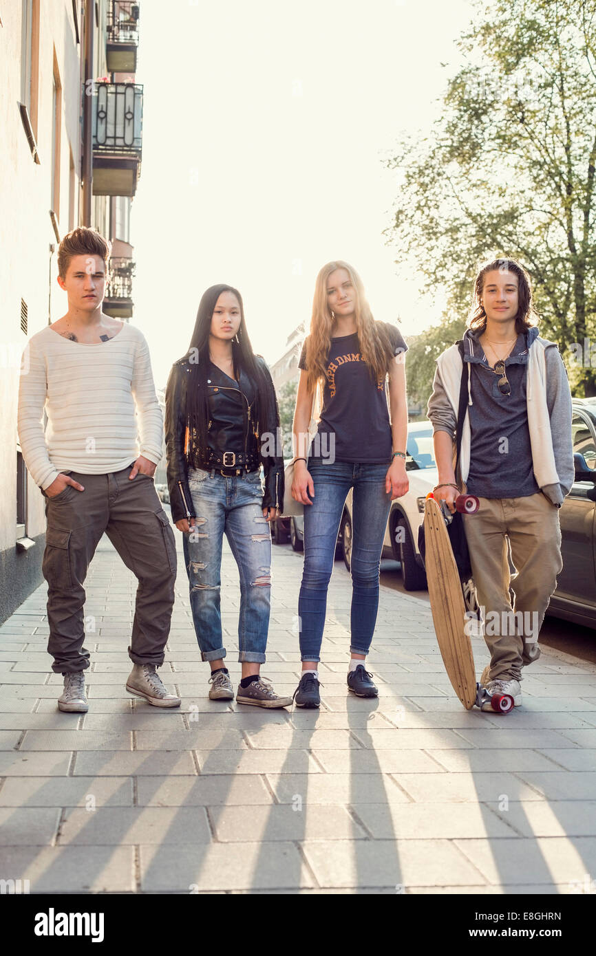 Full length portrait of confident high school students standing on ...