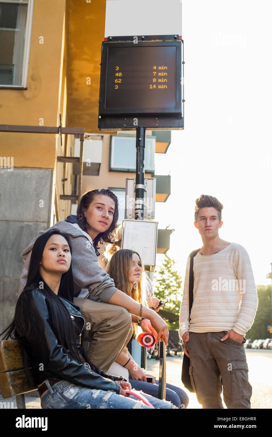 Multiethnic high school students waiting at bus stop Stock Photo - Alamy