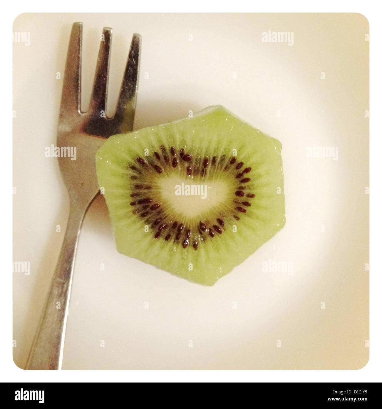 Kiwi fruit with heart shape seeds and fork Stock Photo - Alamy