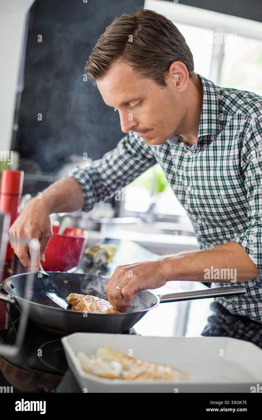 Man cooks fried fish hi-res stock photography and images - Alamy