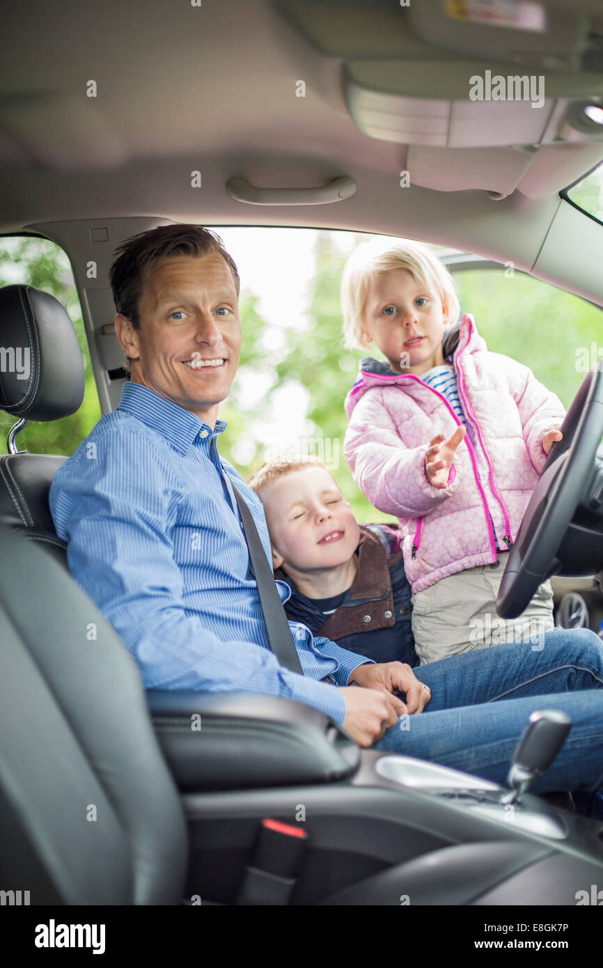 Portrait of happy father with children in car Stock Photo - Alamy