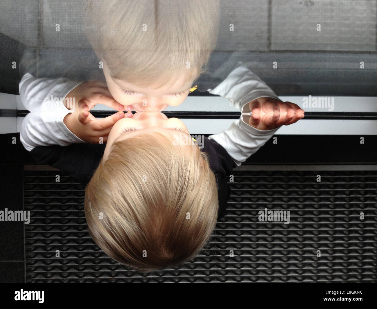 Overhead view of a boy looking through a window Stock Photo - Alamy