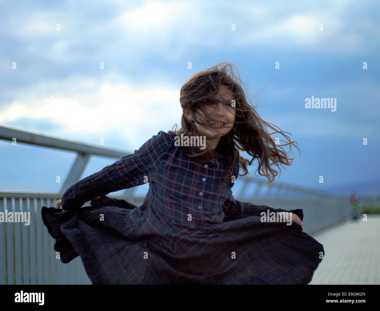 Girl spinning around holding hem of her dress Stock Photo - Alamy