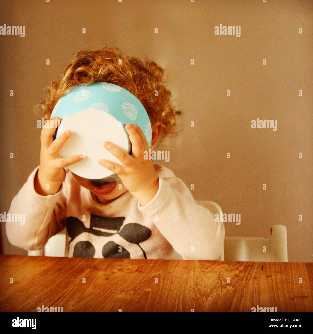 Girl holding a bowl tipping food into her mouth Stock Photo - Alamy