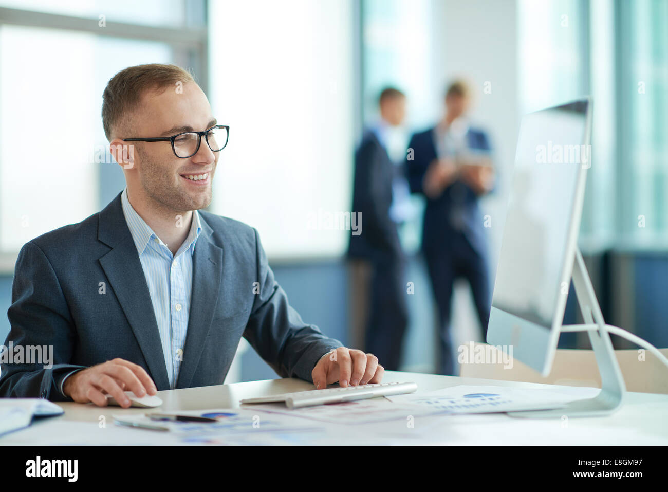 Smiling man sitting at his pc Stock Photo - Alamy