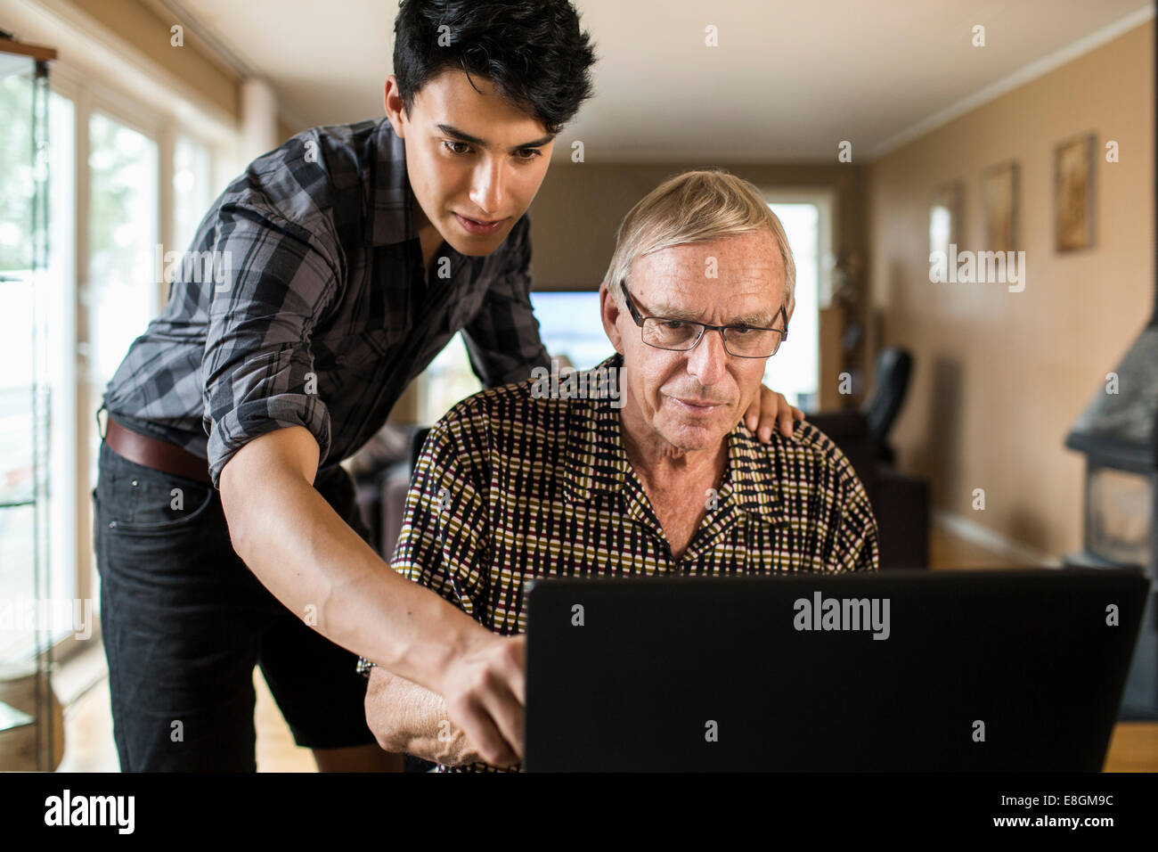 Grandfather assisting grandson using hi-res stock photography and ...