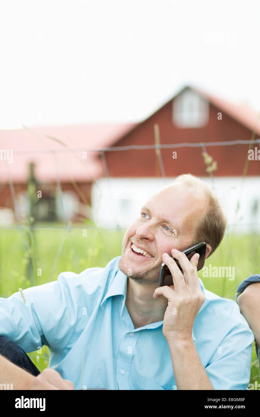Mature man using mobile phone in yard Stock Photo - Alamy