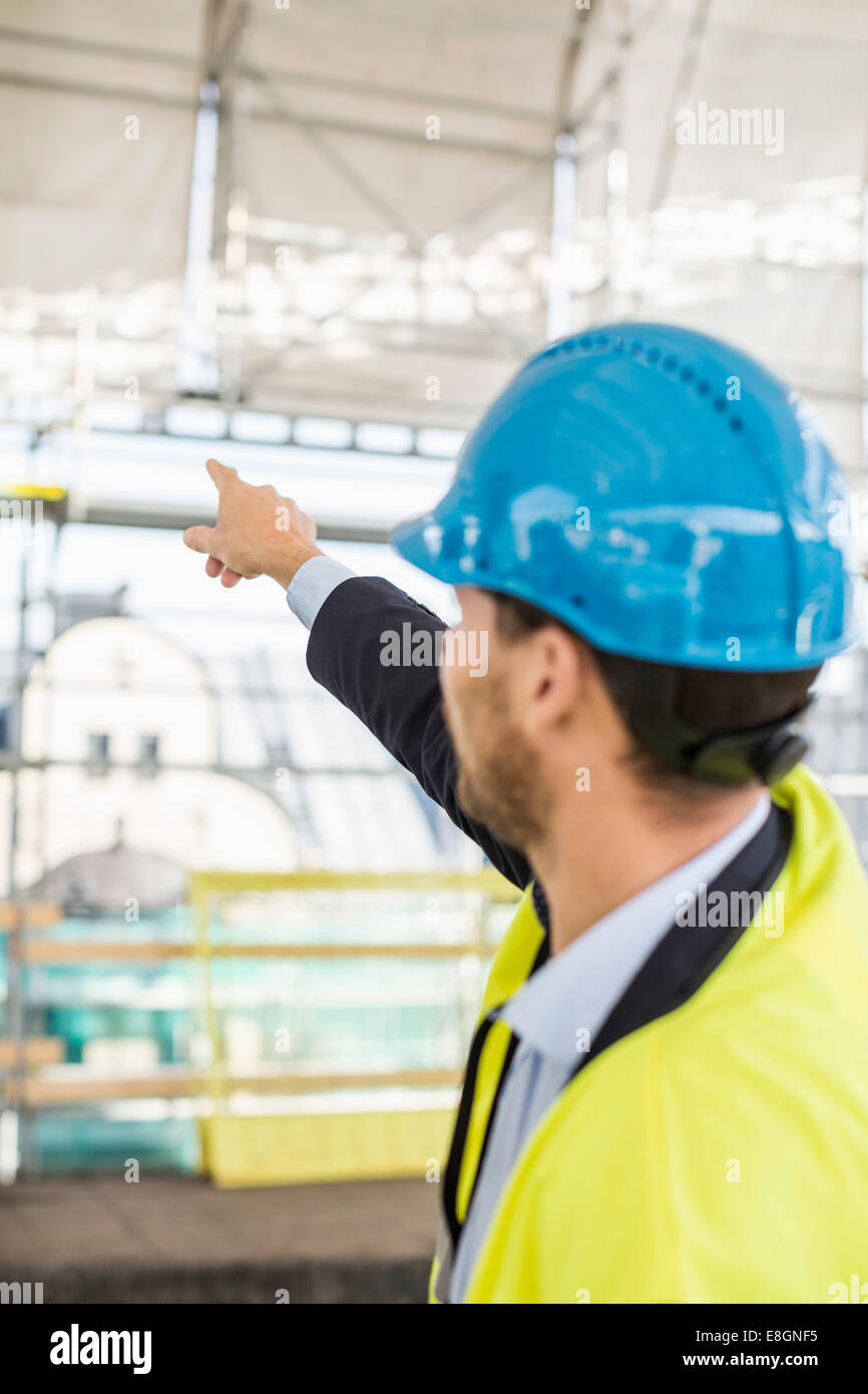 Side view of architect pointing at construction site Stock Photo - Alamy