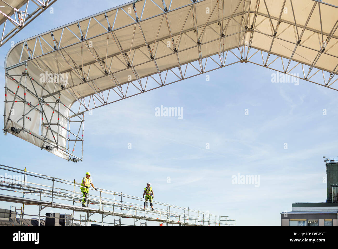 Workers on scaffolding at construction site Stock Photo - Alamy