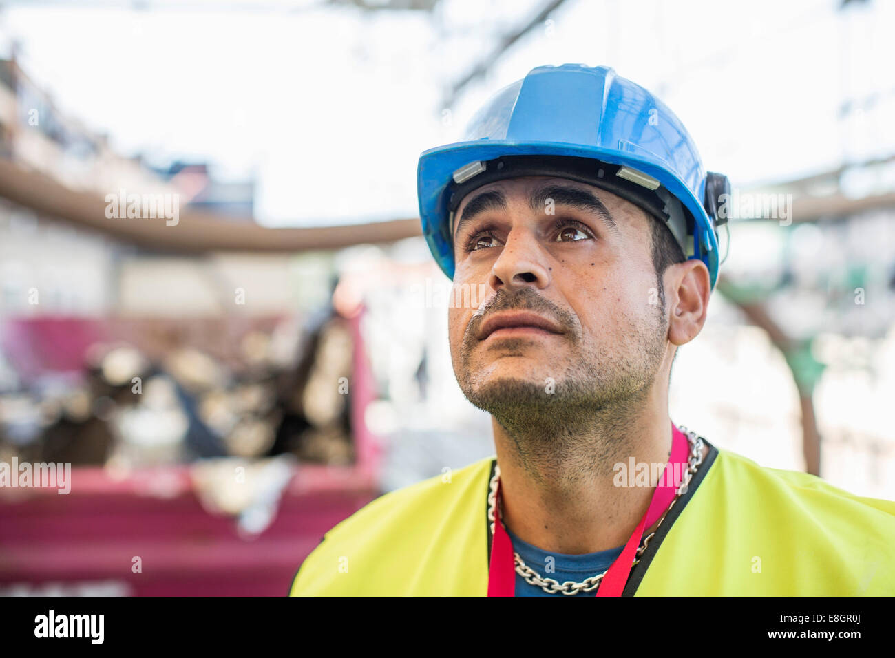 Worker looking up at construction site Stock Photo - Alamy