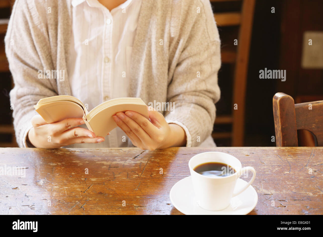 Young Japanese Woman Reading A Book In A Cafe Stock Photo - Alamy