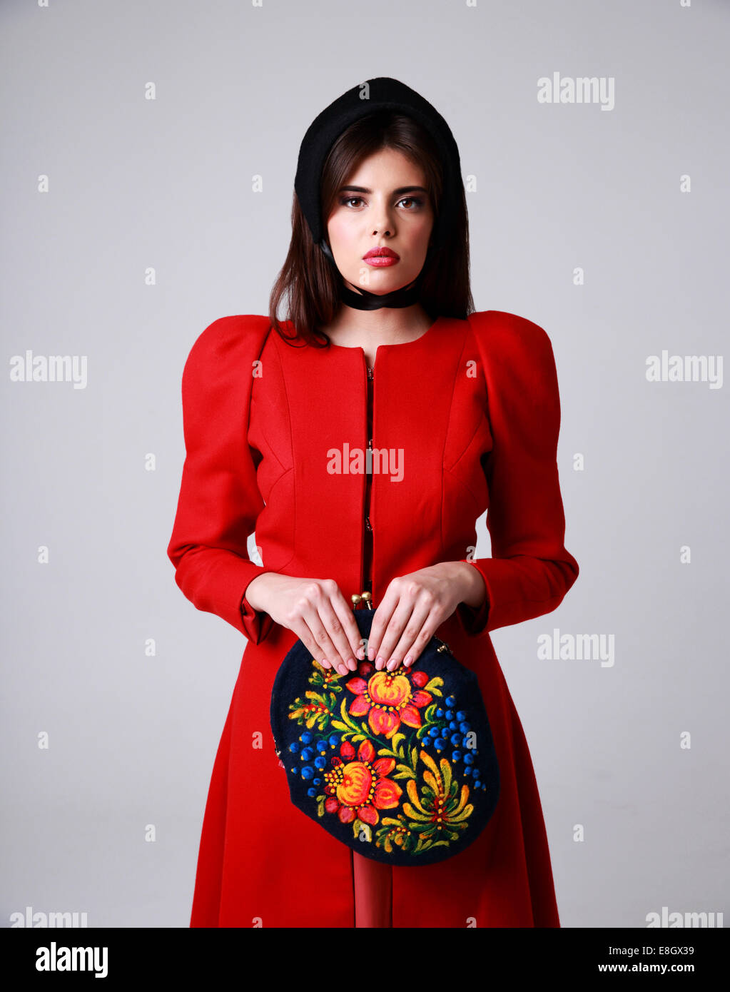 Portrait of a beautiful woman in red dress over gray background Stock ...