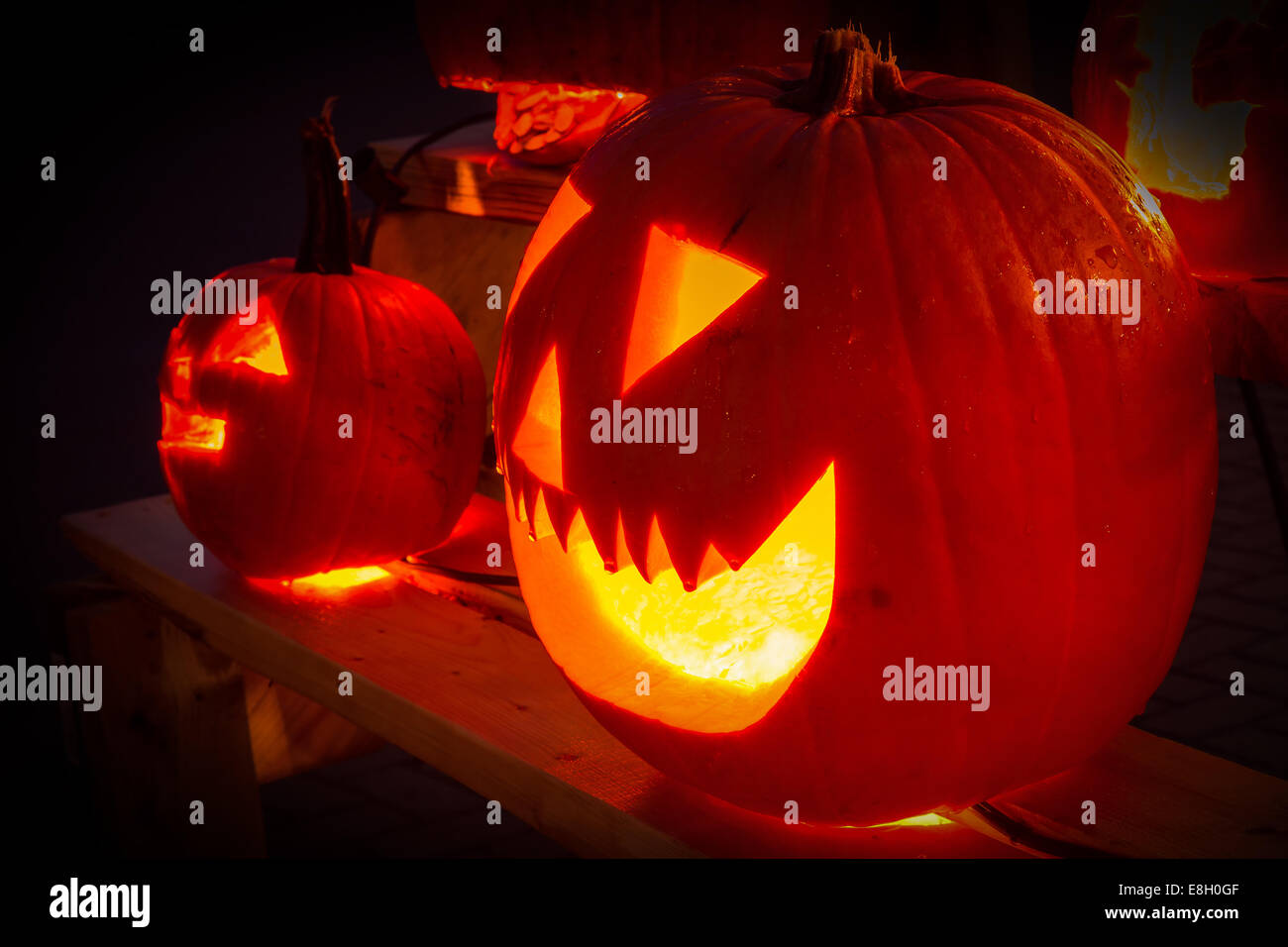 Smiling hand carved Halloween pumpkin glowing in the dark Stock Photo ...