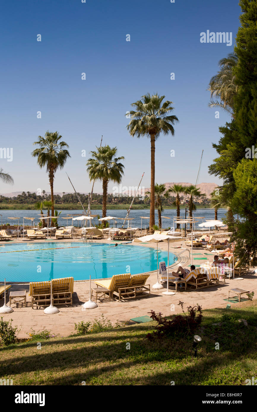 Egypt, Luxor, Sheraton Luxor Resort, guests relaxing in sun by swimming ...