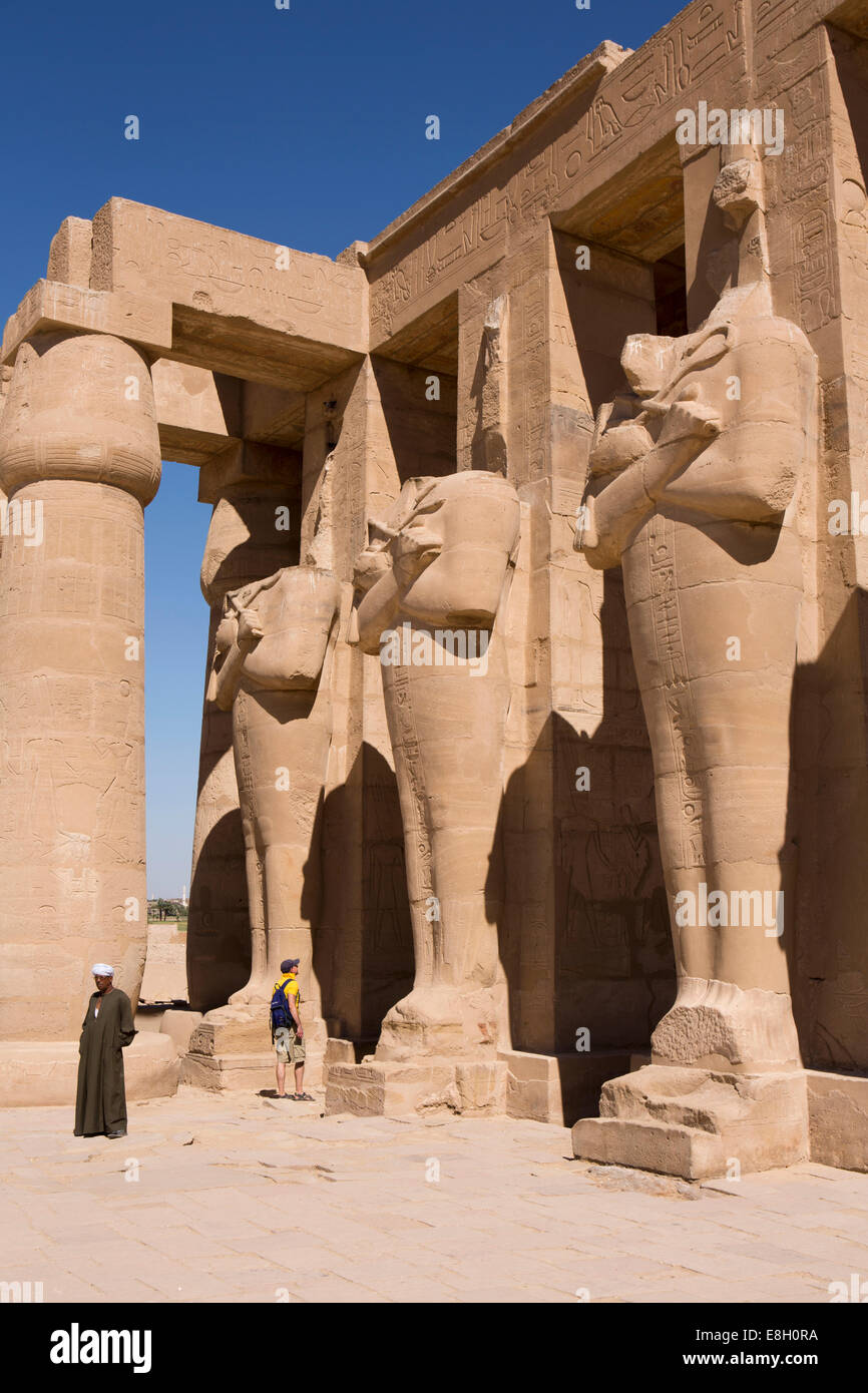 Egypt, Luxor, Ramesseum, tourist and local guide below headless statues ...