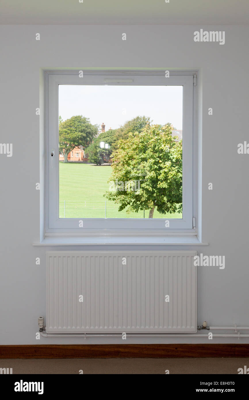 Square window looking out on trees with radiator Stock Photo - Alamy