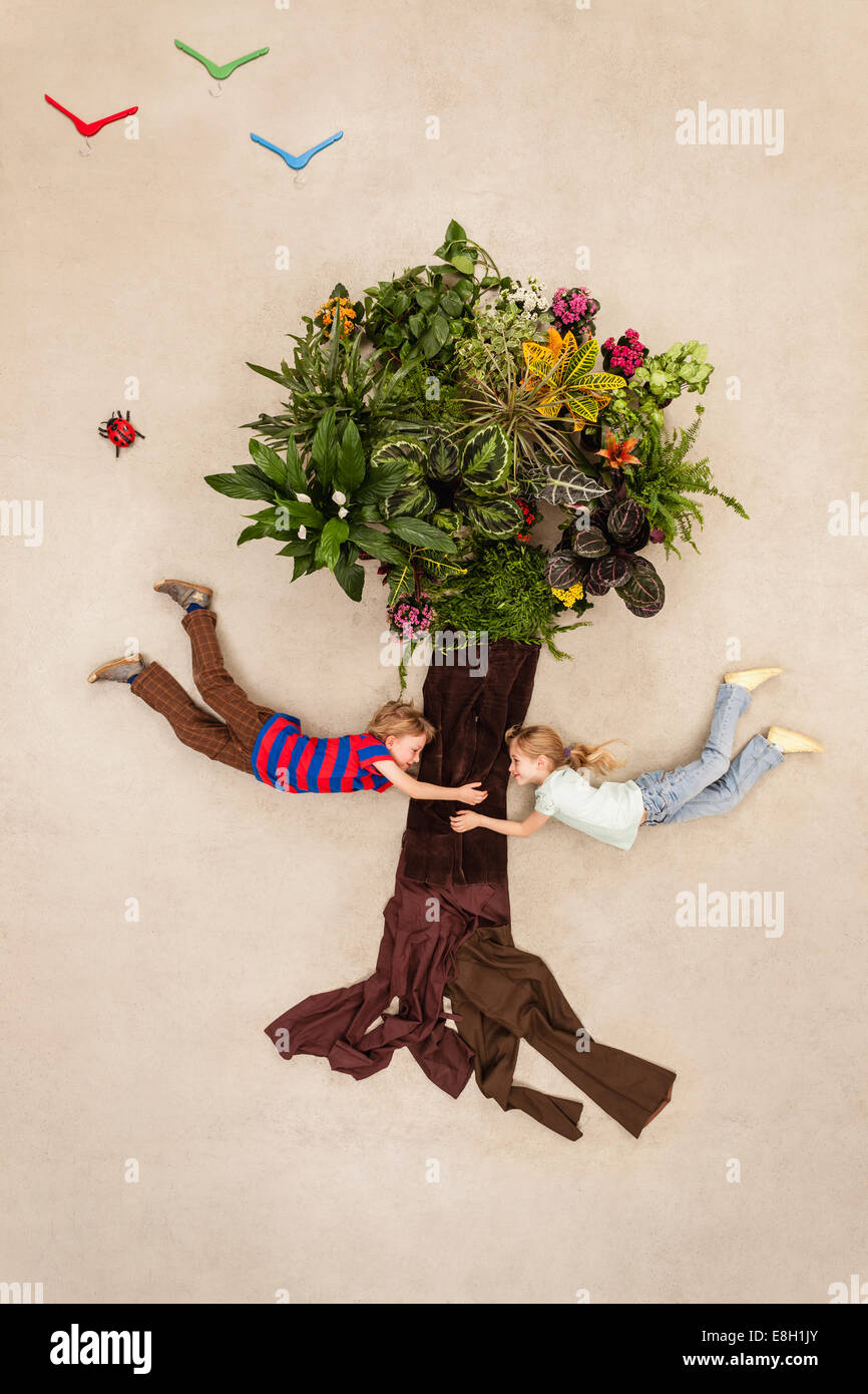 Boy and girl holding onto tree Stock Photo - Alamy