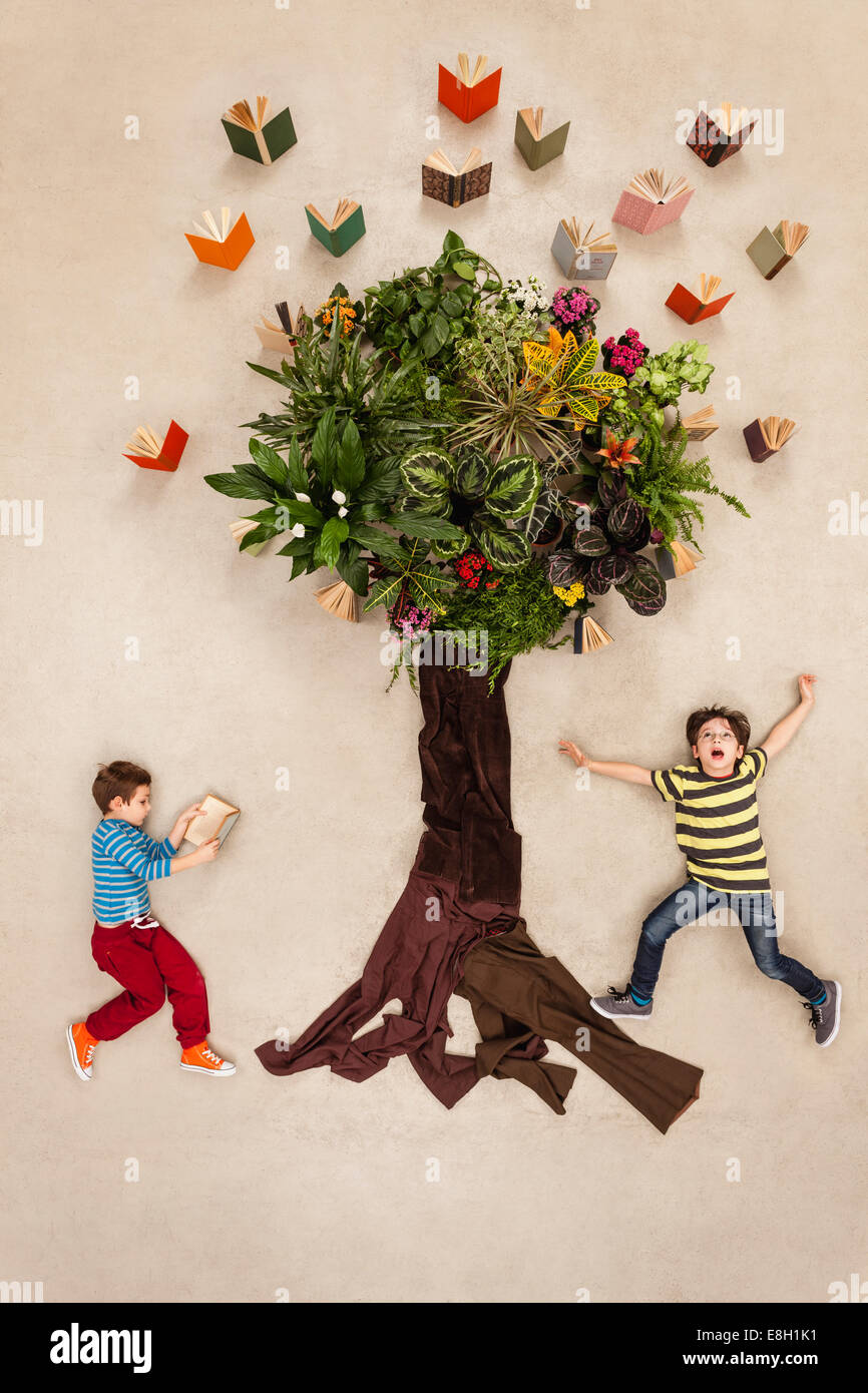 Children watching books flying out of tree Stock Photo - Alamy