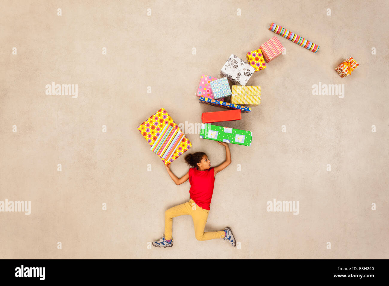 Girl balancing stack of birthday presents Stock Photo - Alamy