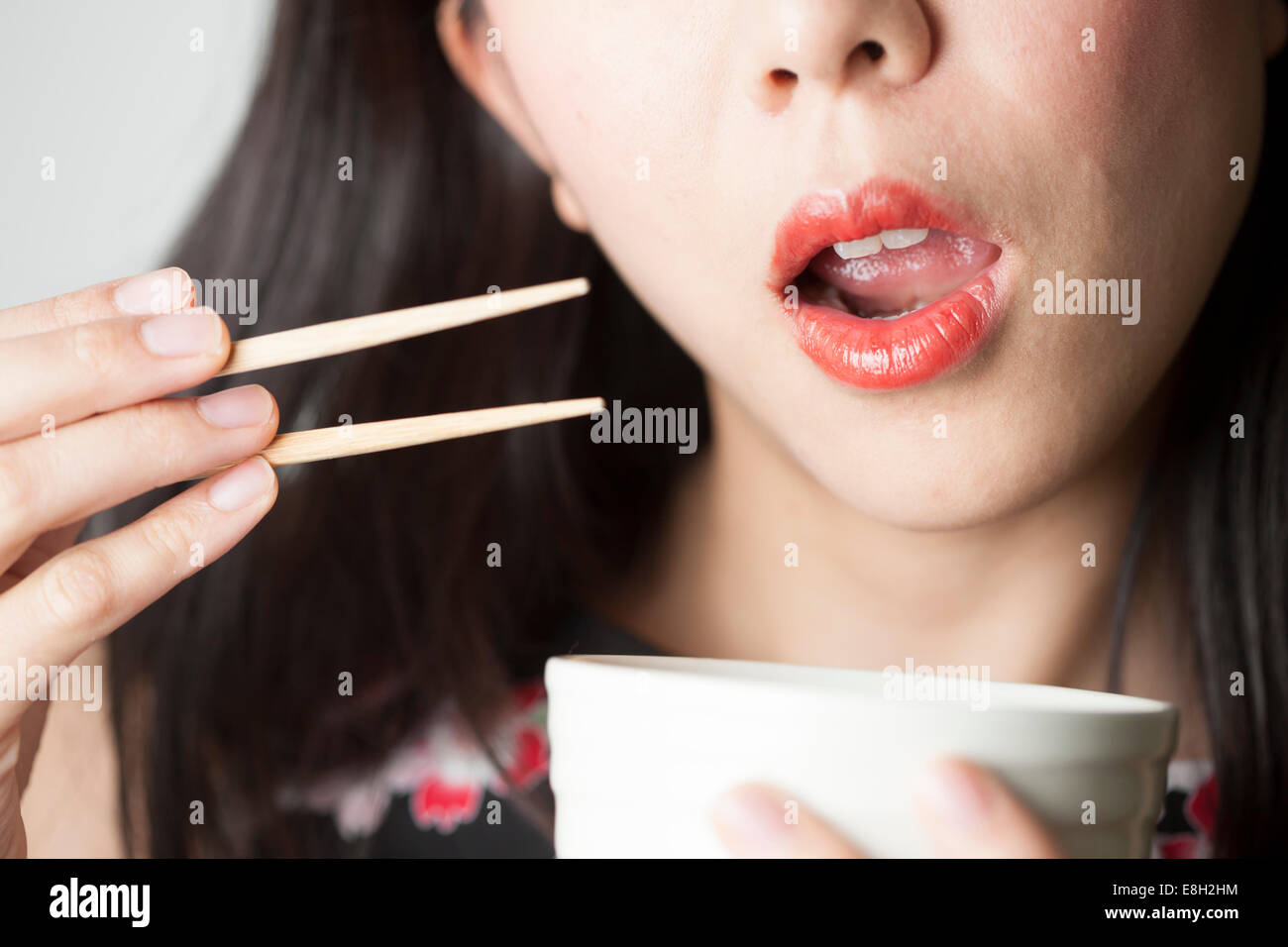 Asian woman eating with chopsticks Stock Photo - Alamy