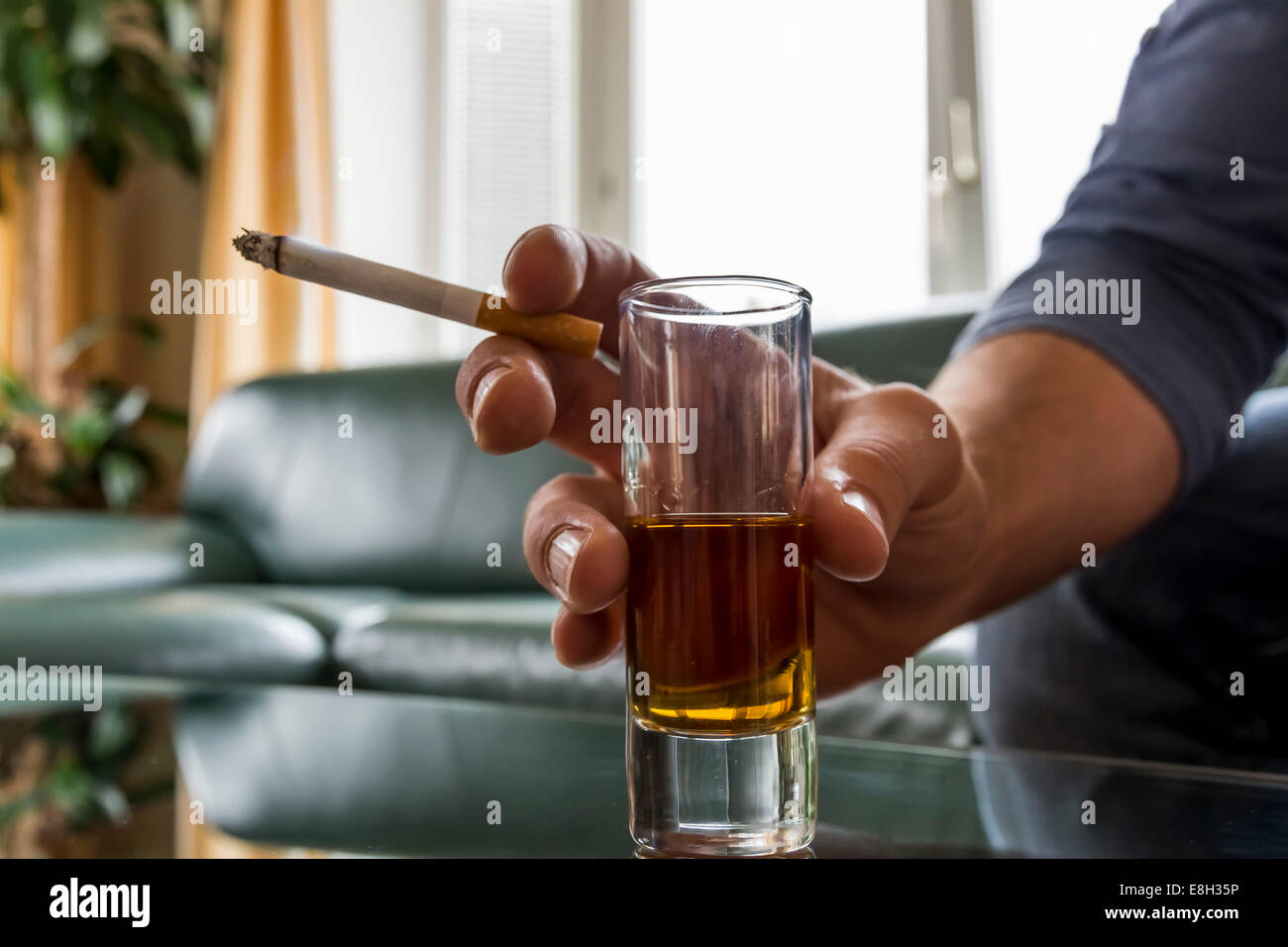 Hand holding cigarette and shot glass Stock Photo - Alamy