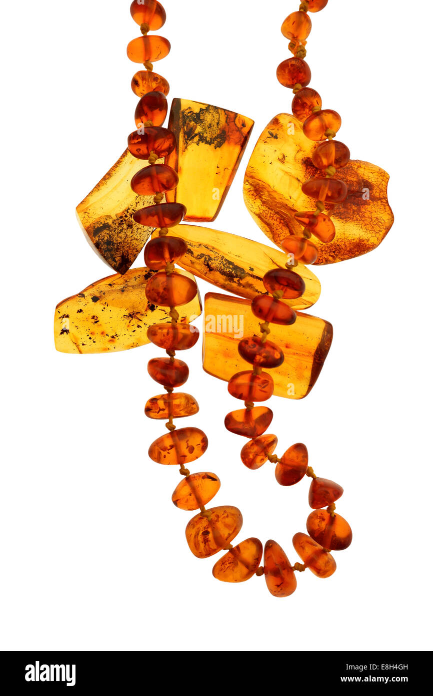 Amber beads necklace and polished amber pieces in front of white ...