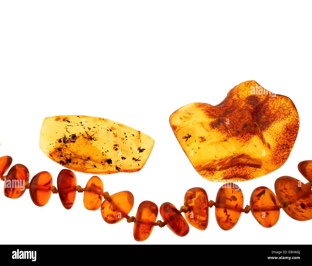 Amber beads necklace and polished amber pieces in front of white ...