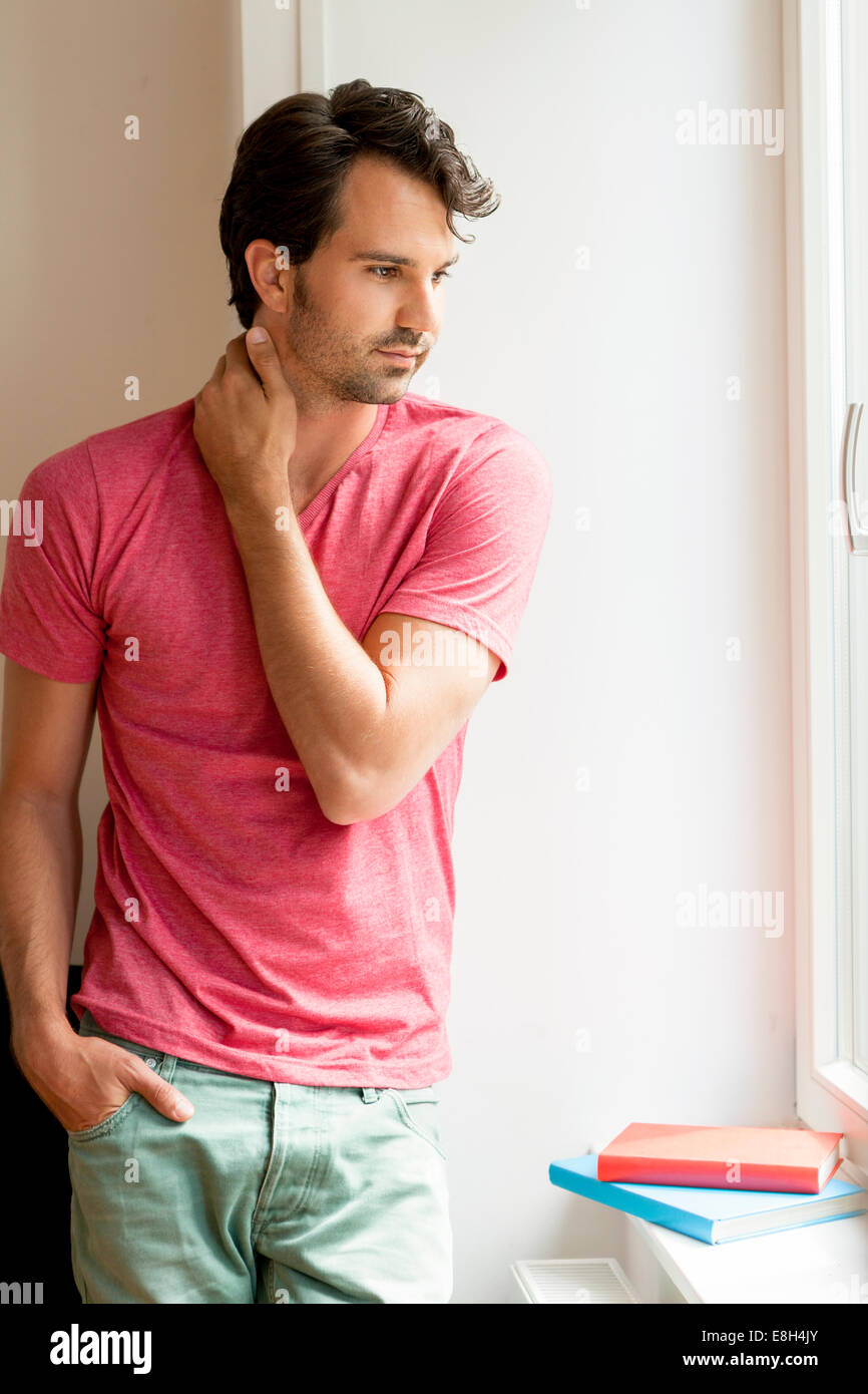 Drowsy young man standing at the window Stock Photo - Alamy