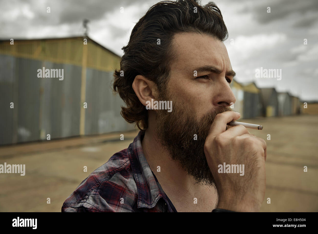 Man with full beard smoking cigarette Stock Photo - Alamy