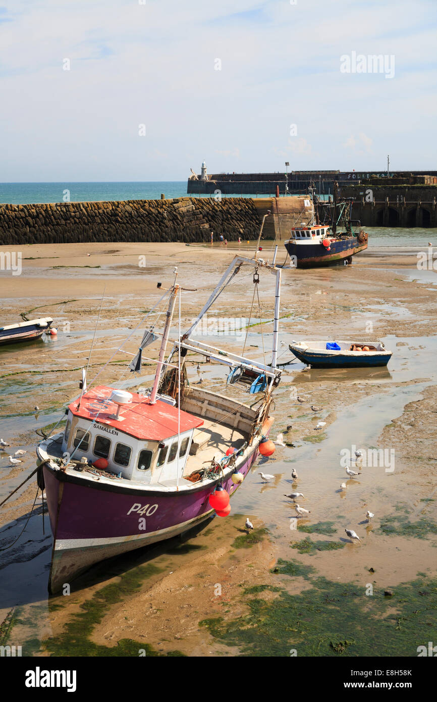 Working fishing boats beached at low tide in Folkestone Harbour Stock ...