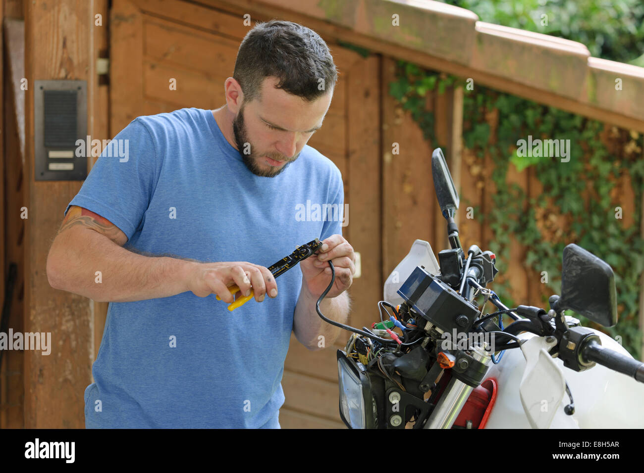 Young man repairing enduro motorcycle Stock Photo - Alamy