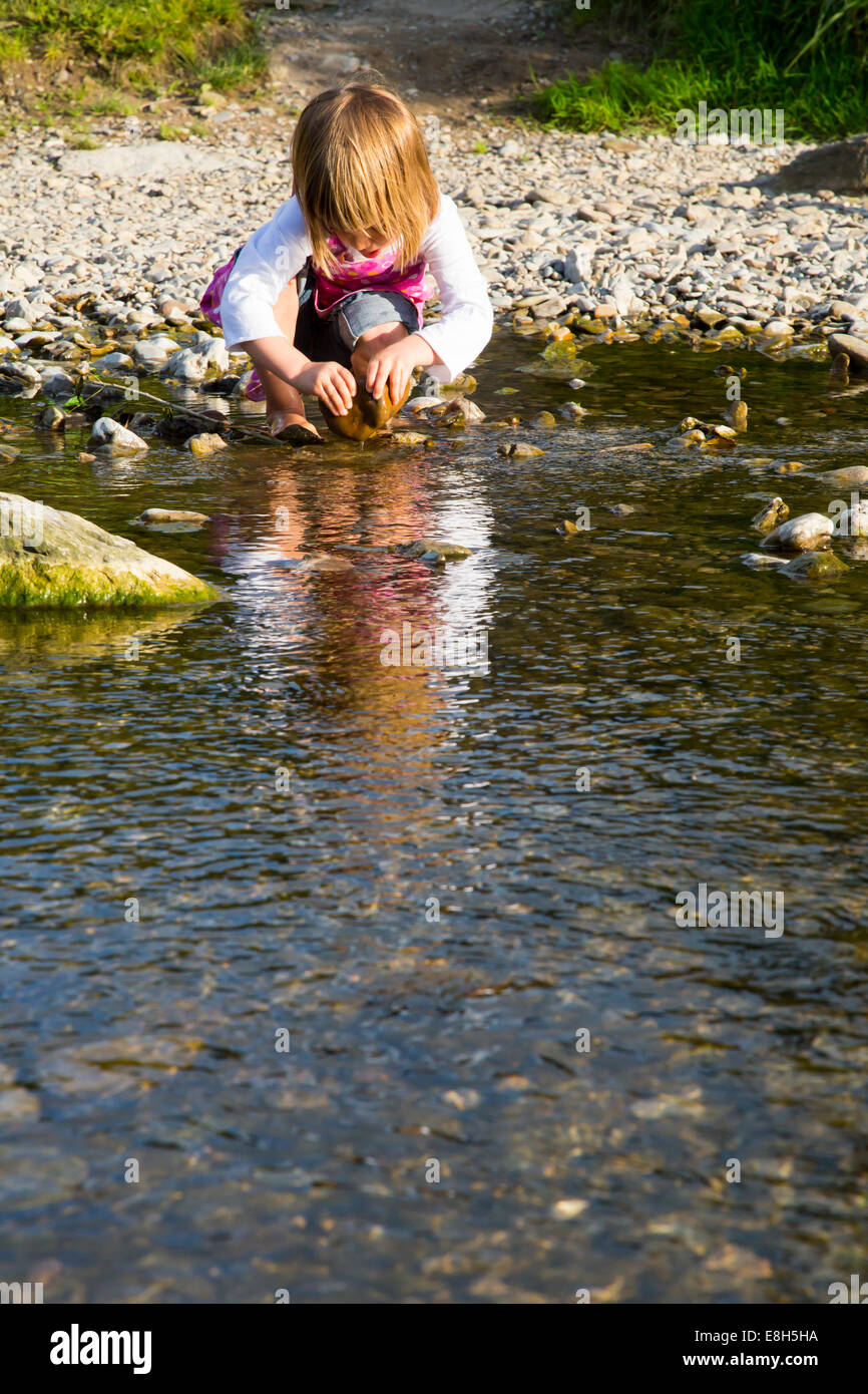 Little girl playing at riverside Stock Photo - Alamy