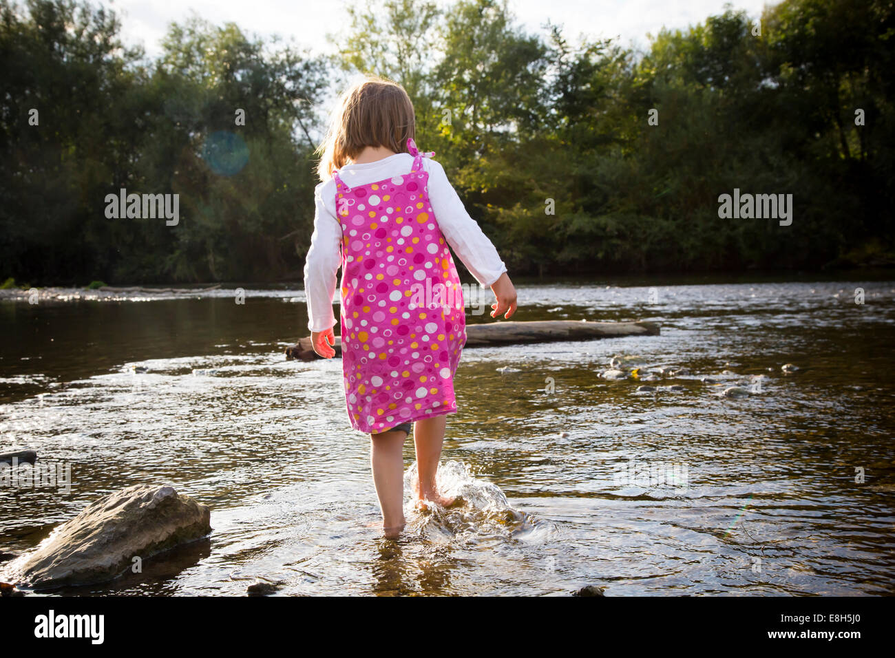 Little girl playing at riverside Stock Photo - Alamy