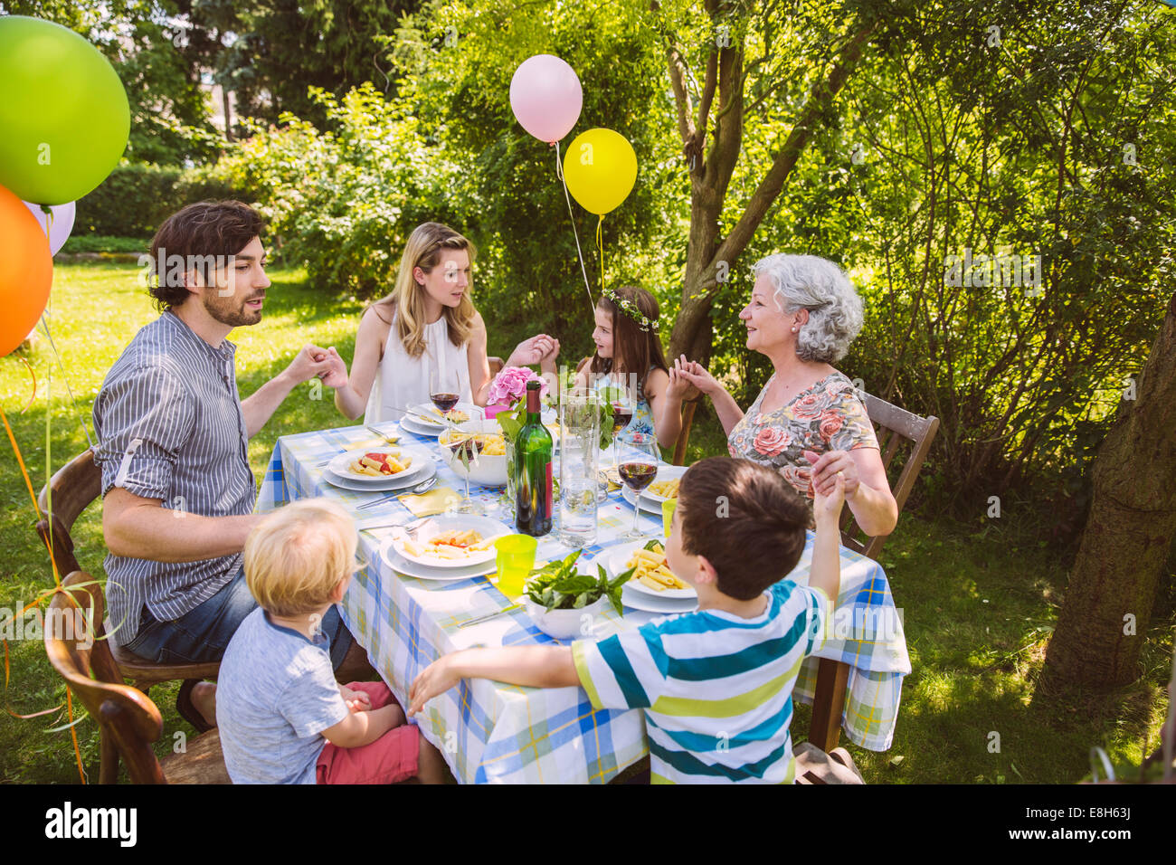 Family of three generations praying at a garden party Stock Photo - Alamy